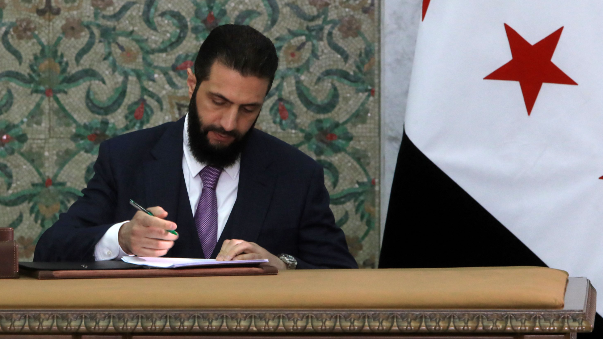 Syria interim leader signs new constitution, laying path for 5-yr ...